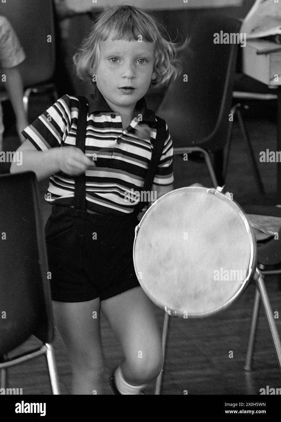 The boy sets the beat with the mallet and the hand drum [automated ...