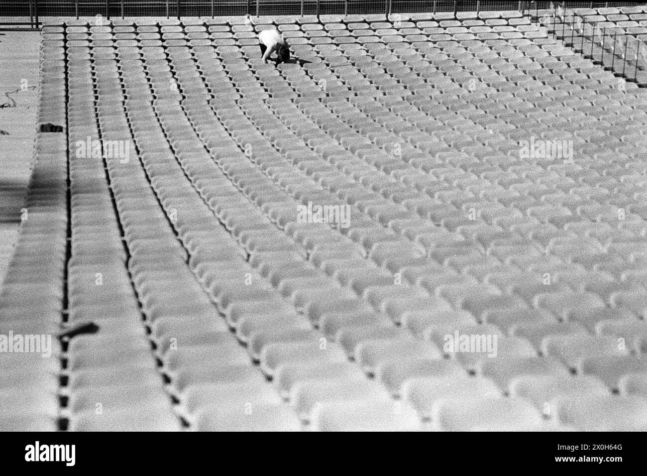 A single worker assembles the seats in Munich's Olympic Stadium ...