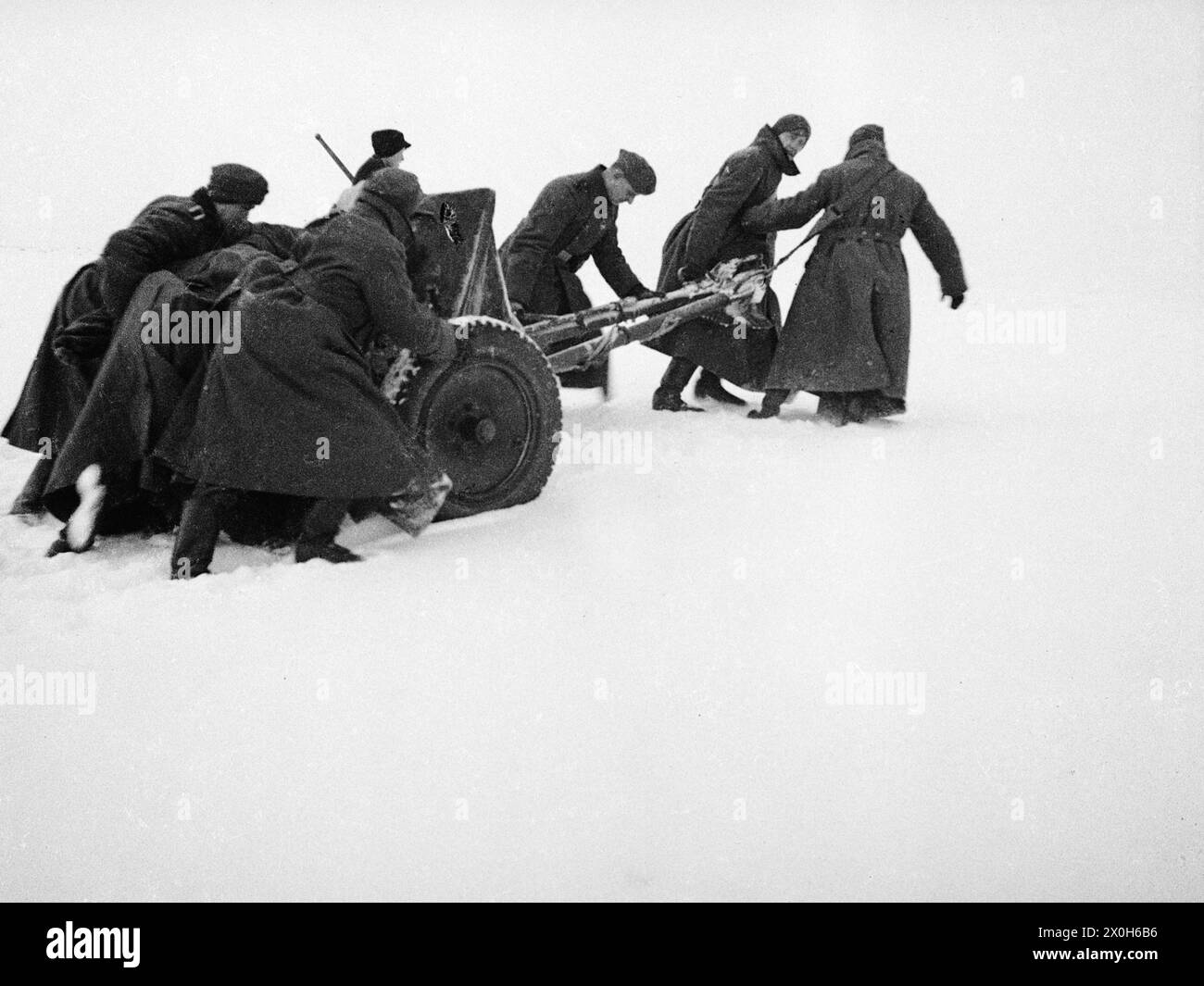 A squad pulls and pushes a 3.7cm Pak 36 through the deep snow on the ...
