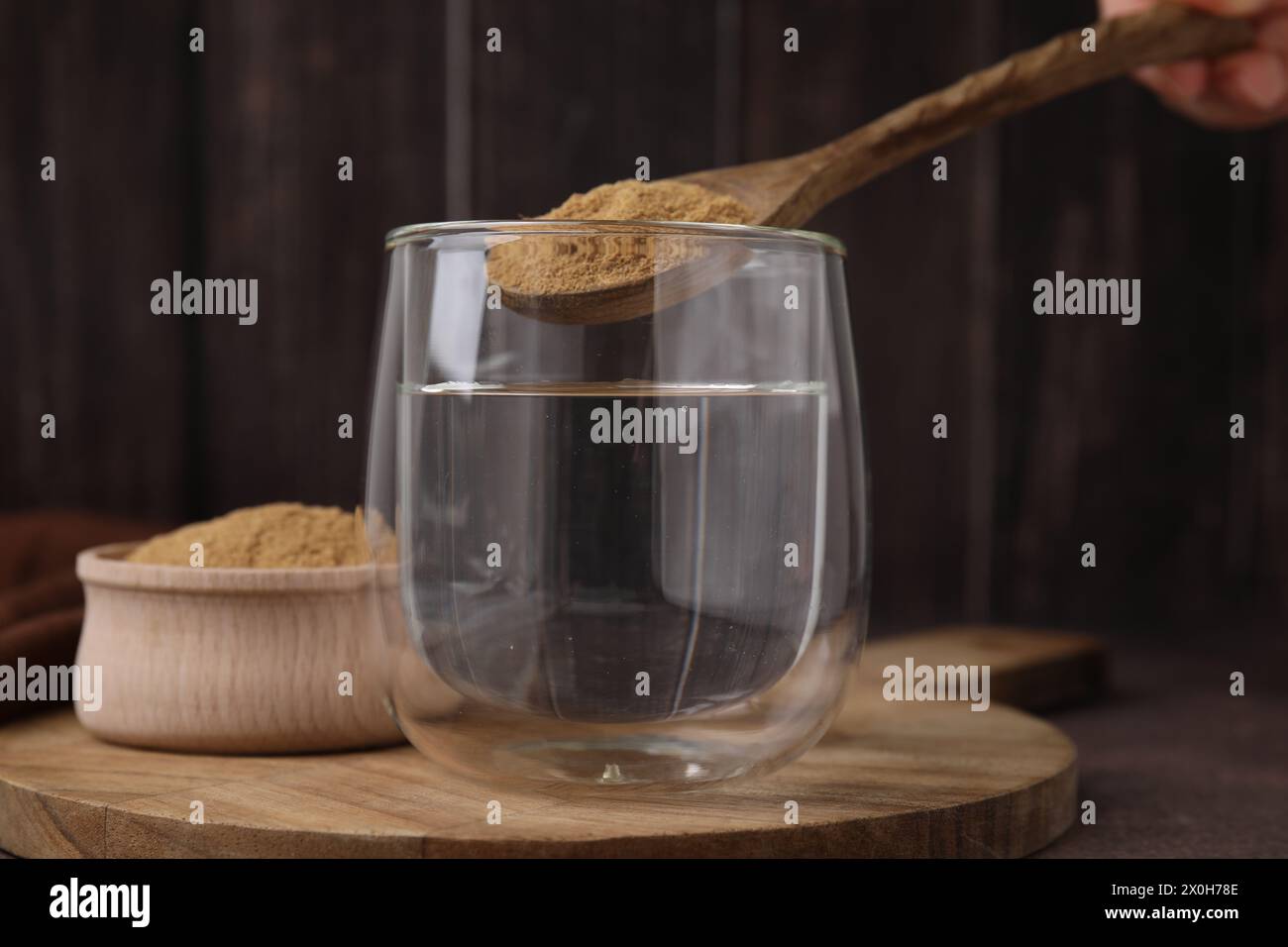 Dietary fiber. Woman adding psyllium husk powder into water at table ...