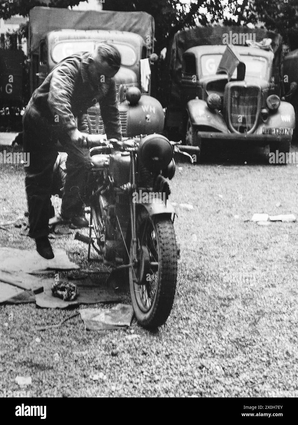 A German motorcyclist maintains his motorcycle. The picture was taken ...
