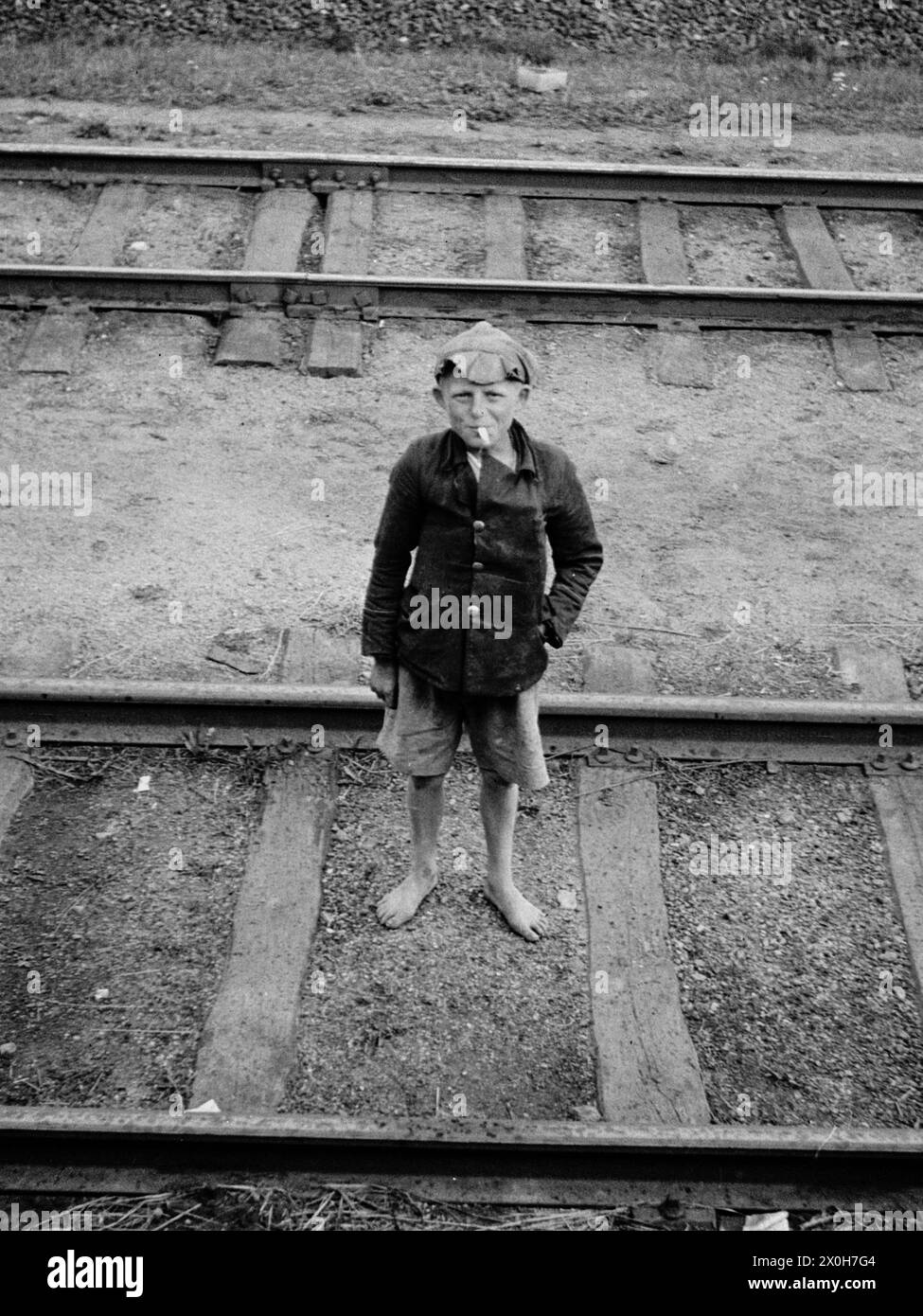 Barefoot but smoking cigarettes, a young Frenchman observes the ...