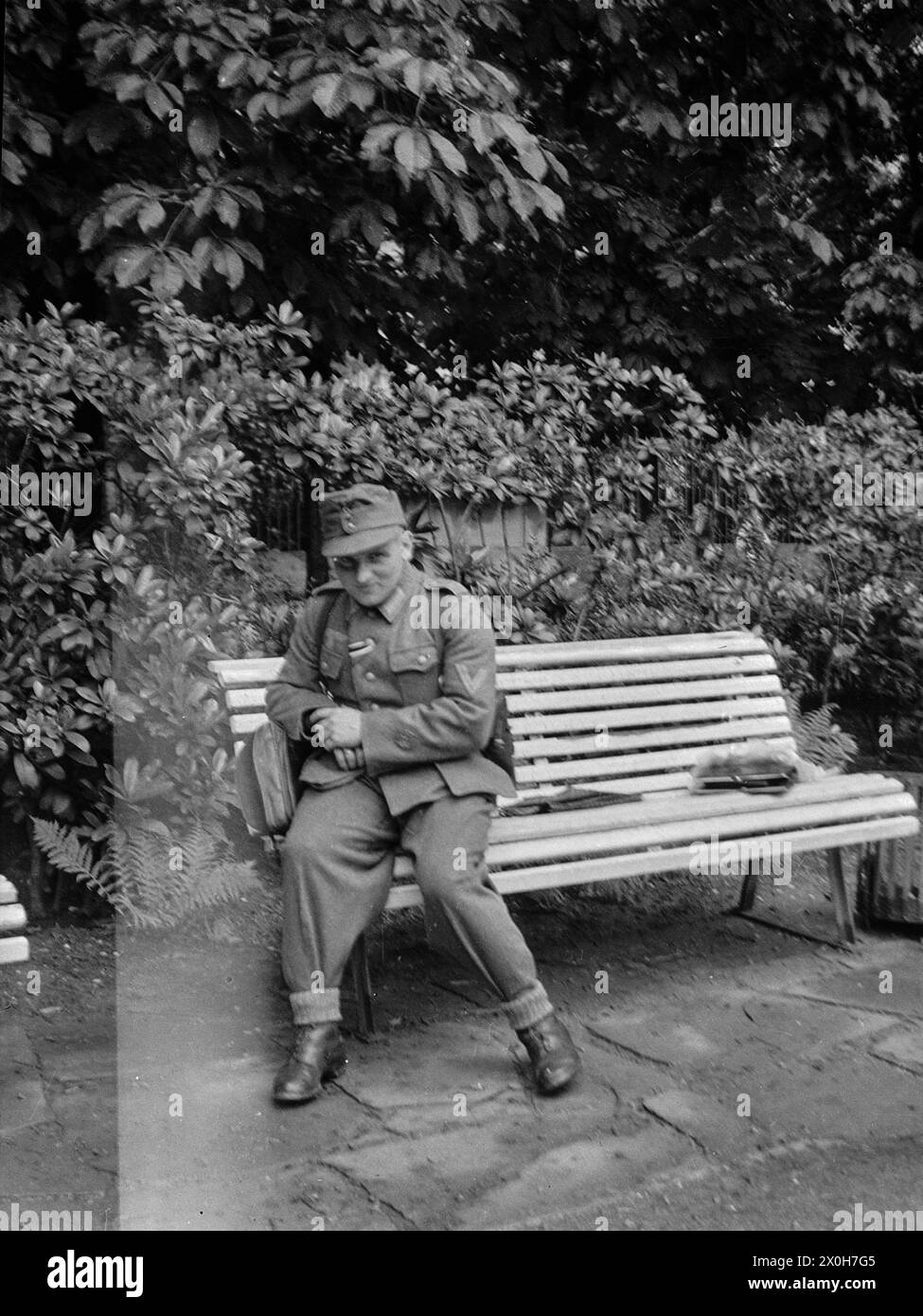 Sitting on a park bench, the soldier allows himself to be photographed ...