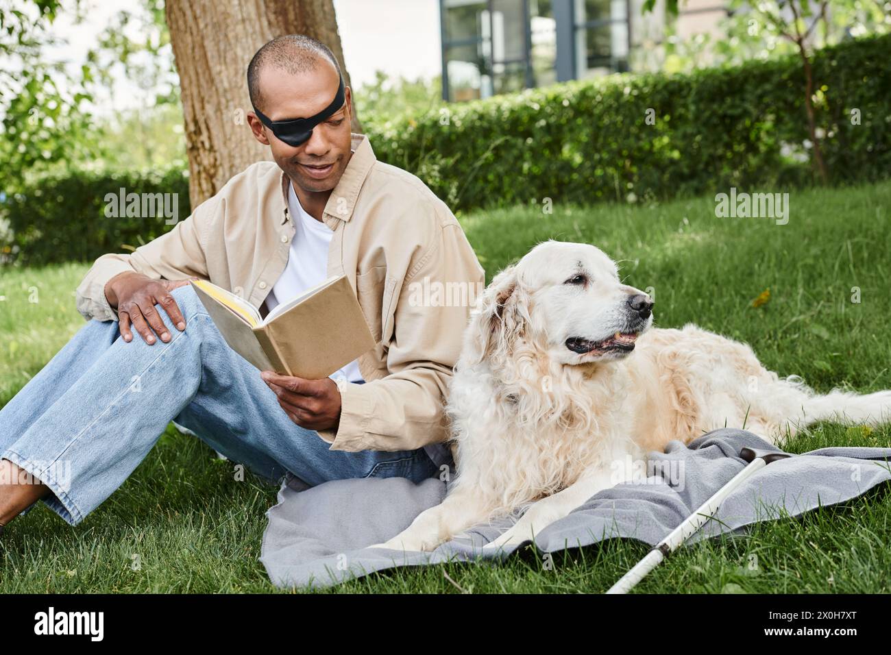 A myasthenia gravis syndrome man reading a book with his loyal Labrador ...