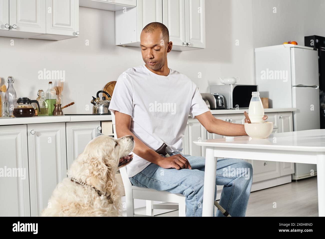 An African American man, disabled, sits at a kitchen table with his ...