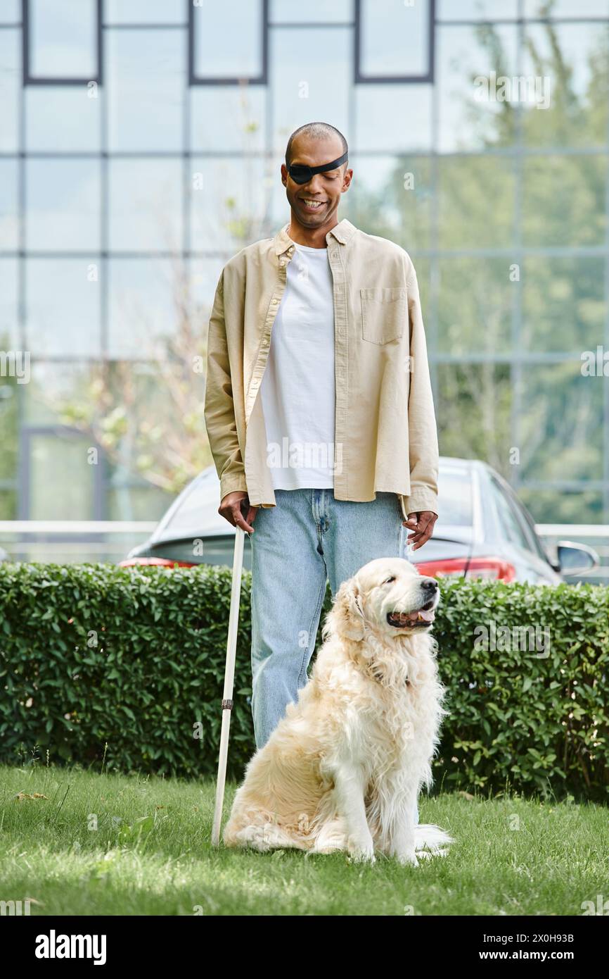 A disabled African American man standing alongside a Labrador dog on a ...