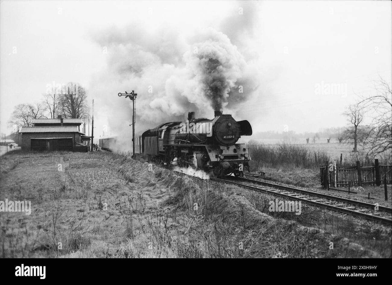 A train with a class 41 1137-3 steam locomotive arrives at a station in ...