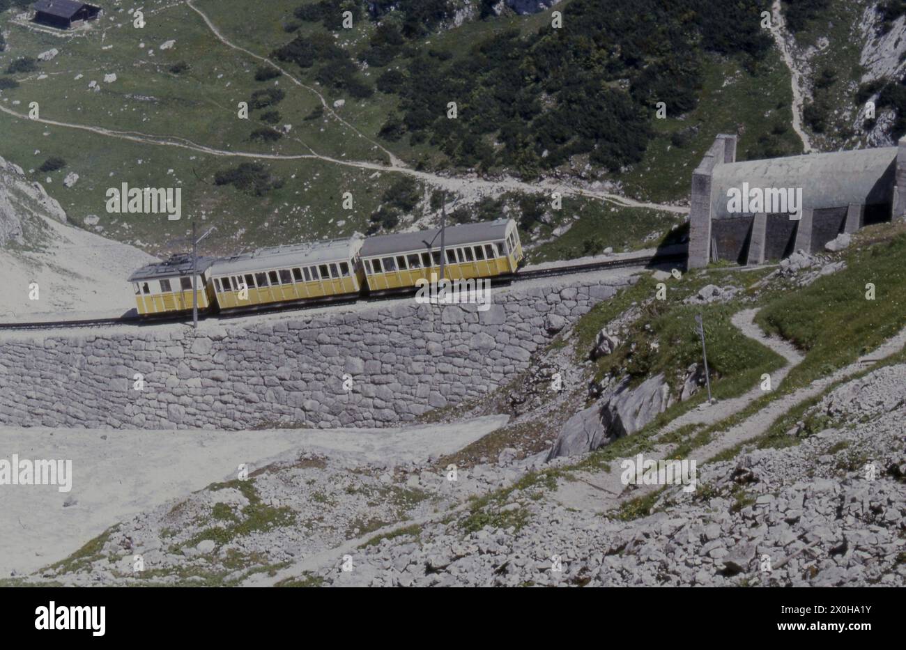A yellow train of the Wendelsteinbahn before entering a tunnel in the ...