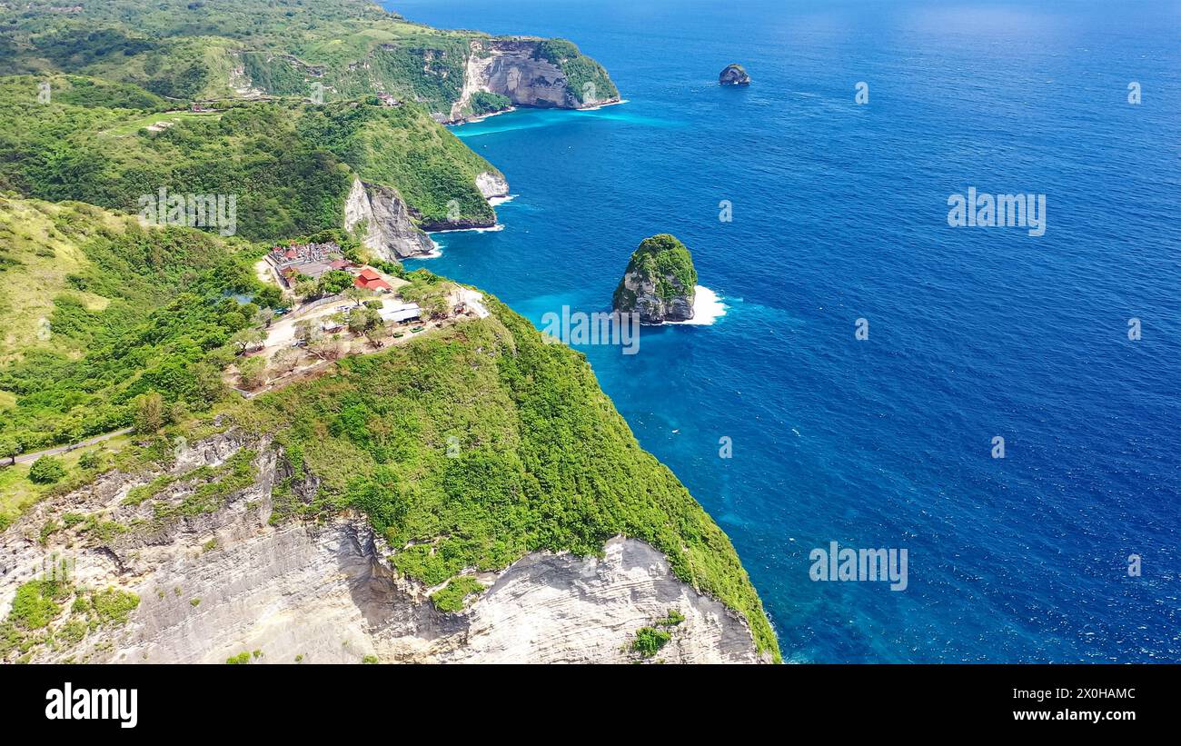 Blue sea washes rocky mountains covered forest. Separate rocks in water ...