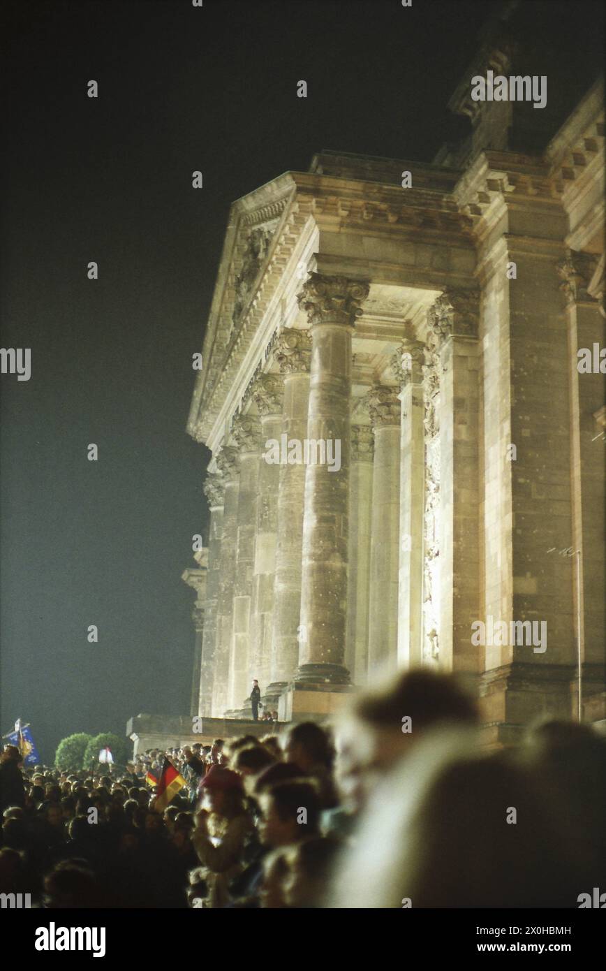 A crowd celebrates German reunification in front of the Reichstag ...
