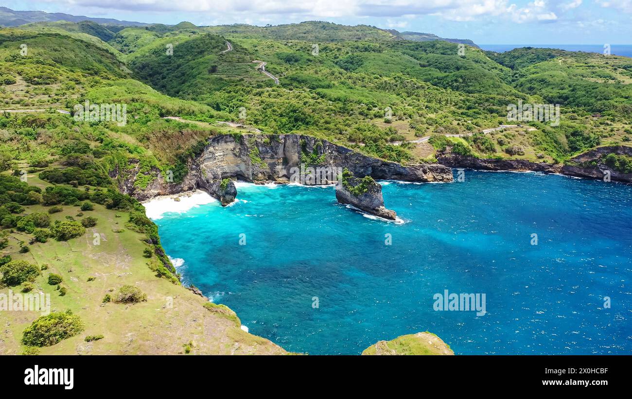 Blue sea washes rocky mountains covered forest. Separate rocks in water ...