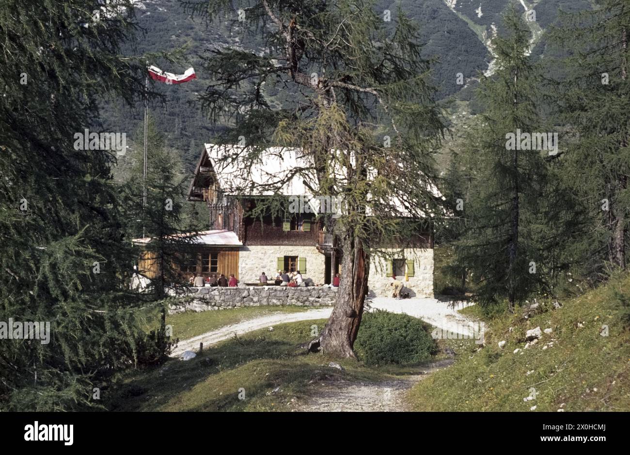 A hiking trail leads to the Alpine Club hut, where guests sit on the ...