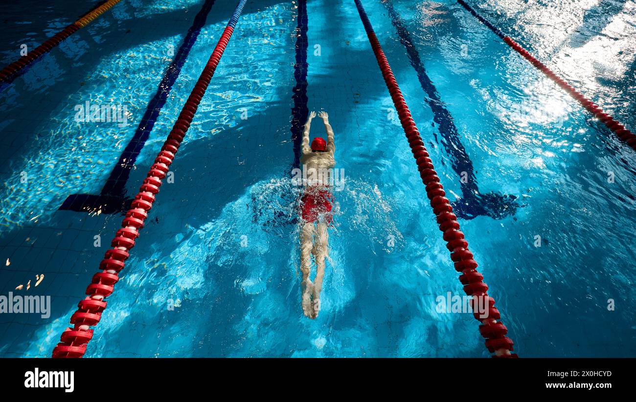 Top view of muscular, athletic young man, swimmer in red cap in motion ...