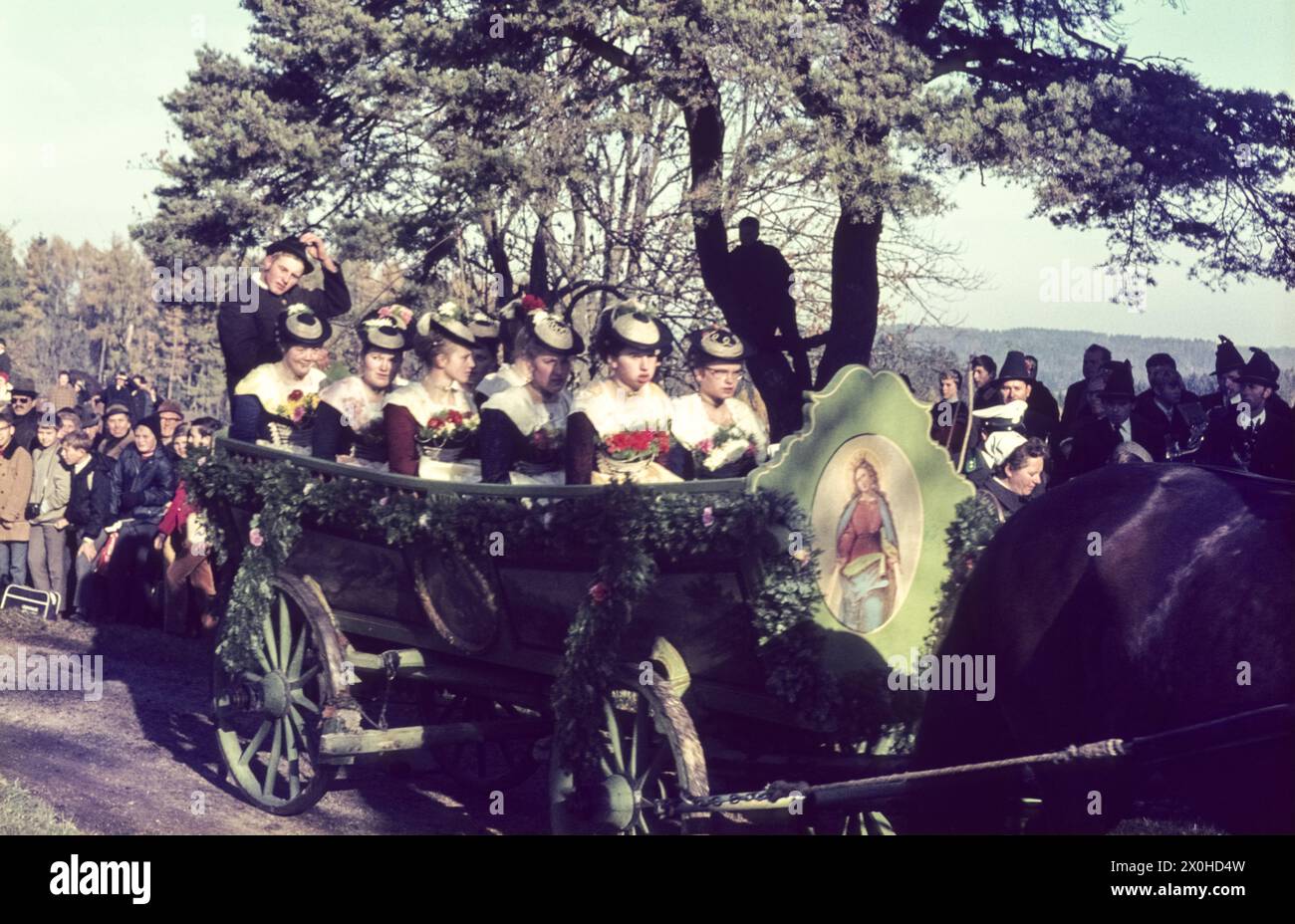 Girls in traditional costumes sit in a carriage at the Leonhardi ride ...