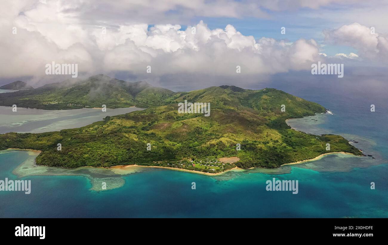 Tropical Fiji island with palm trees and clear blue-green water with ...