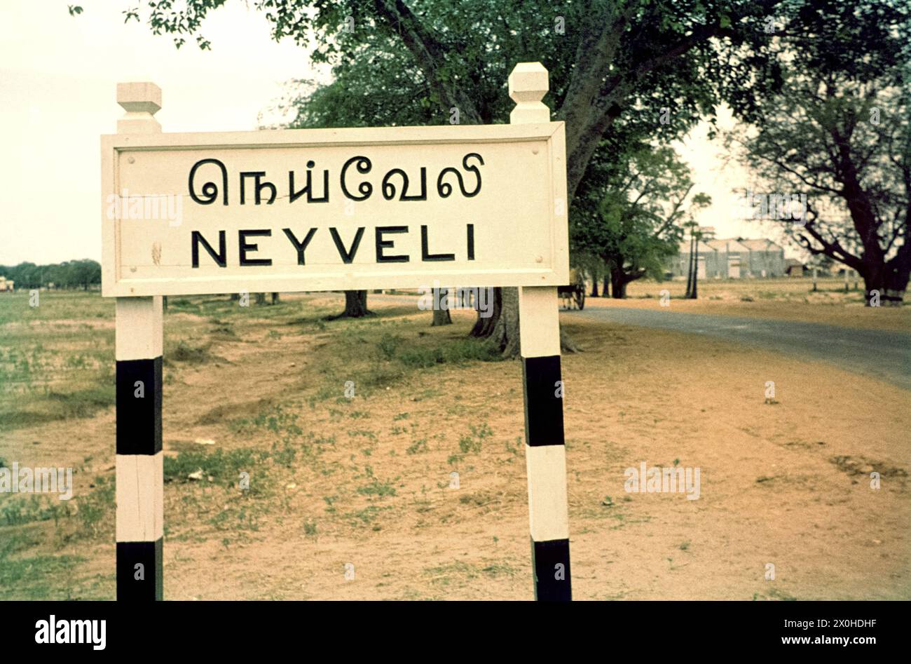 Town sign of Neyveli with street and houses. [automated translation ...