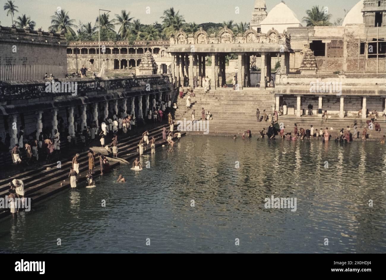 Pilgrims take their ritual bath in the temple pool of the Nataraja ...