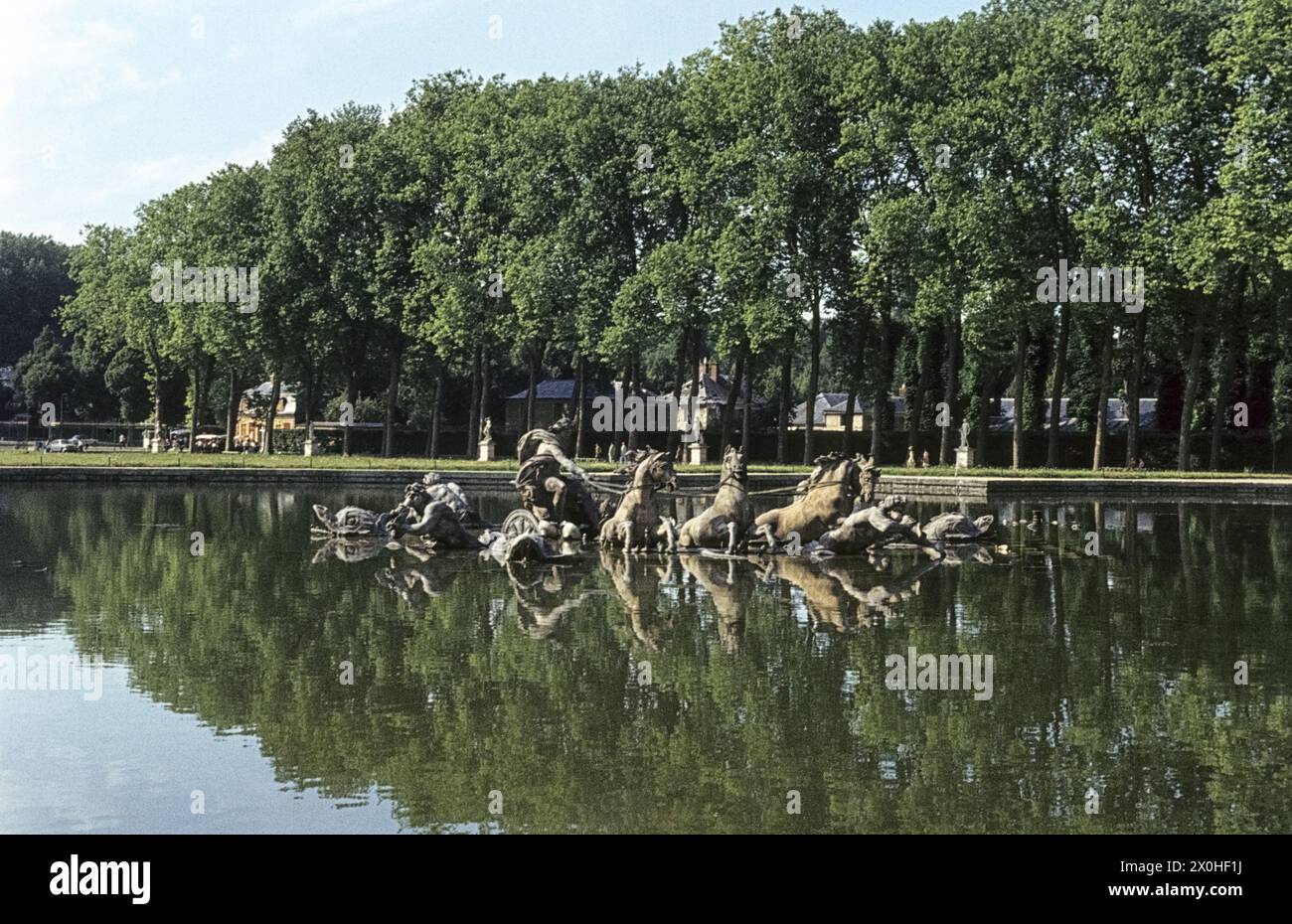 The golden figures of the Apollo Fountain are reflected in the water ...