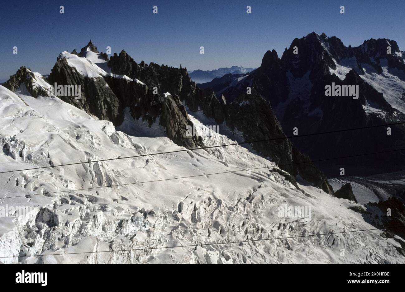 In front, the wire ropes of the VallÃ©e Blanche small gondola lift ...