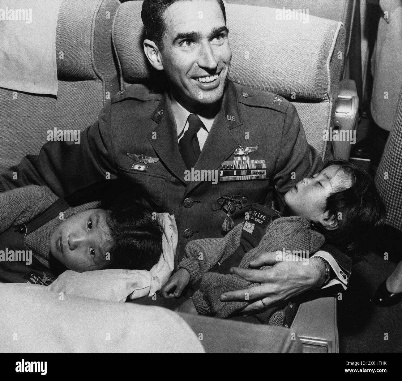 Korean War orphans Chul Hi Jung, left, and Soon Ja Lee rest in the arms ...