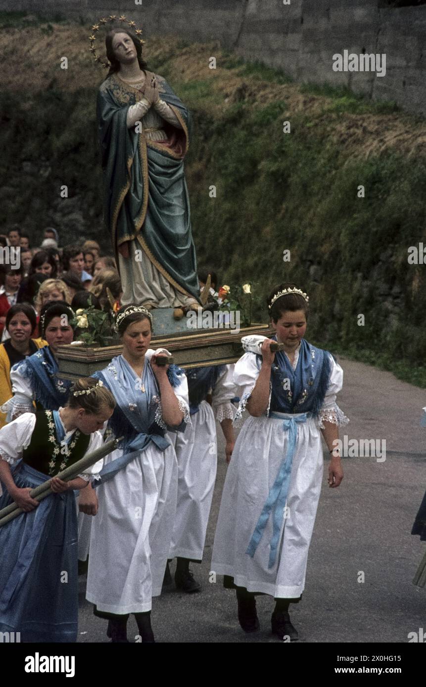 Women in traditional costume carry a statue of the Virgin Mary ...