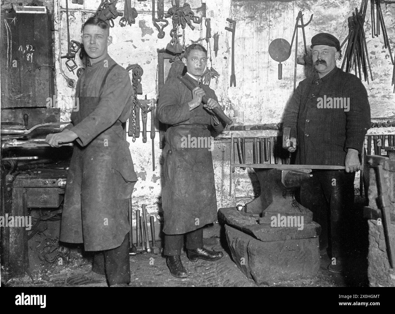 Three blacksmiths with hammer and anvil in a workshop in Diepholz Stock ...