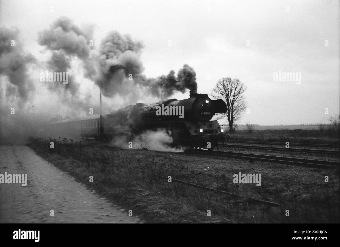 A train with a class 41 1074-8 steam locomotive arrives at a station in ...