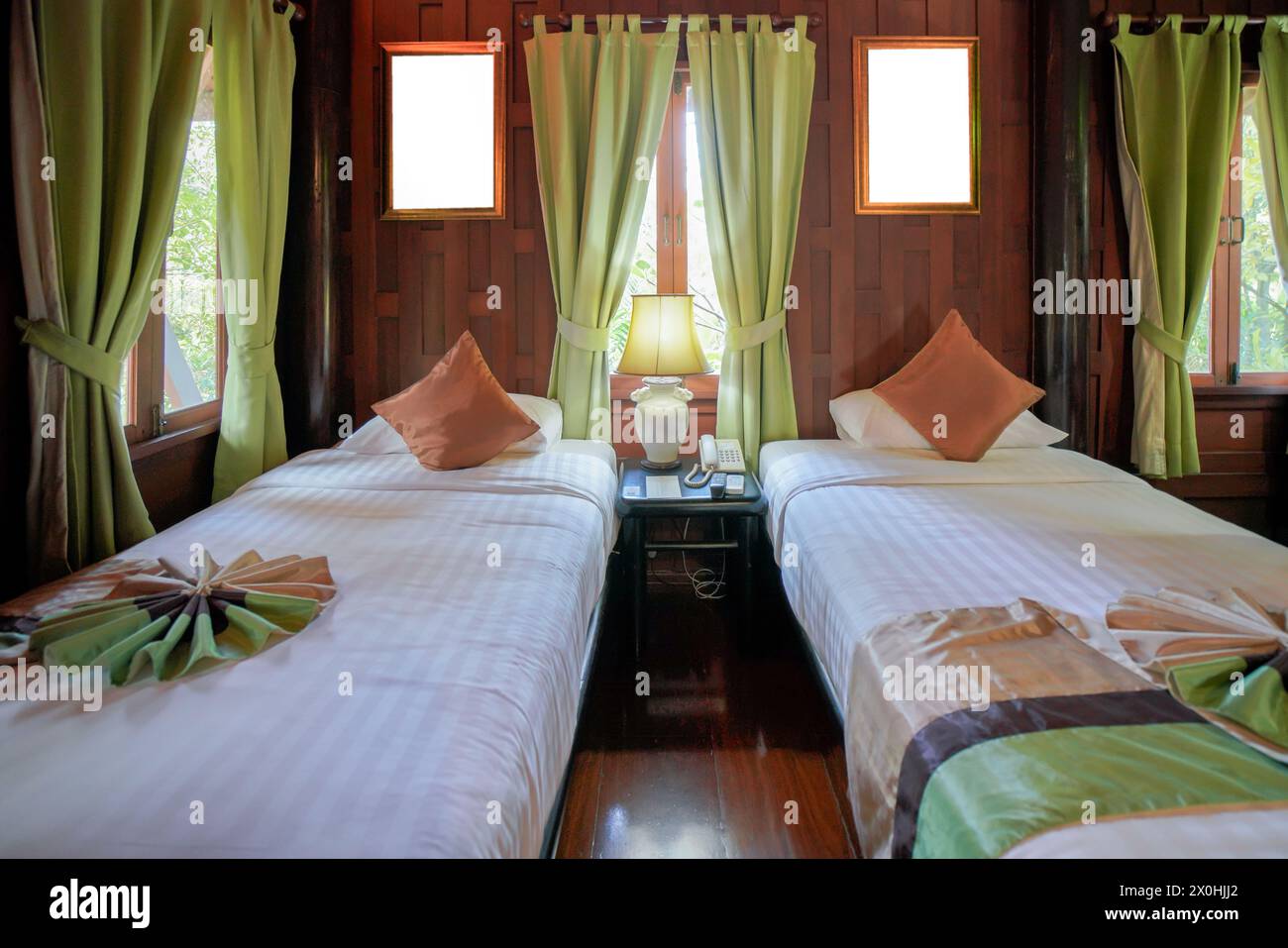 Cozy and intimate twin bedroom featuring traditional Thai decor, wooden ...