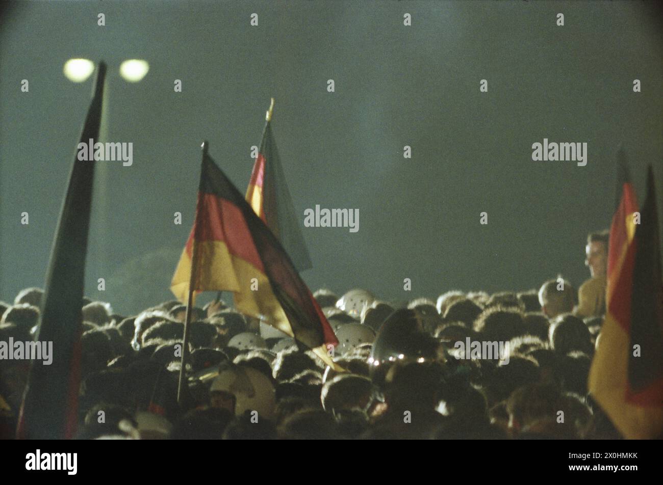 A crowd celebrates German reunification in front of the Reichstag ...