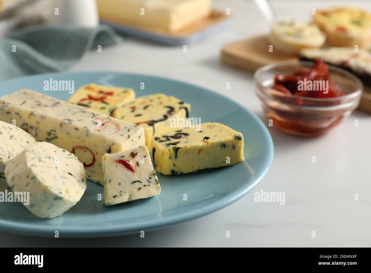 Different types of tasty butter and chili pepper on white marble table ...