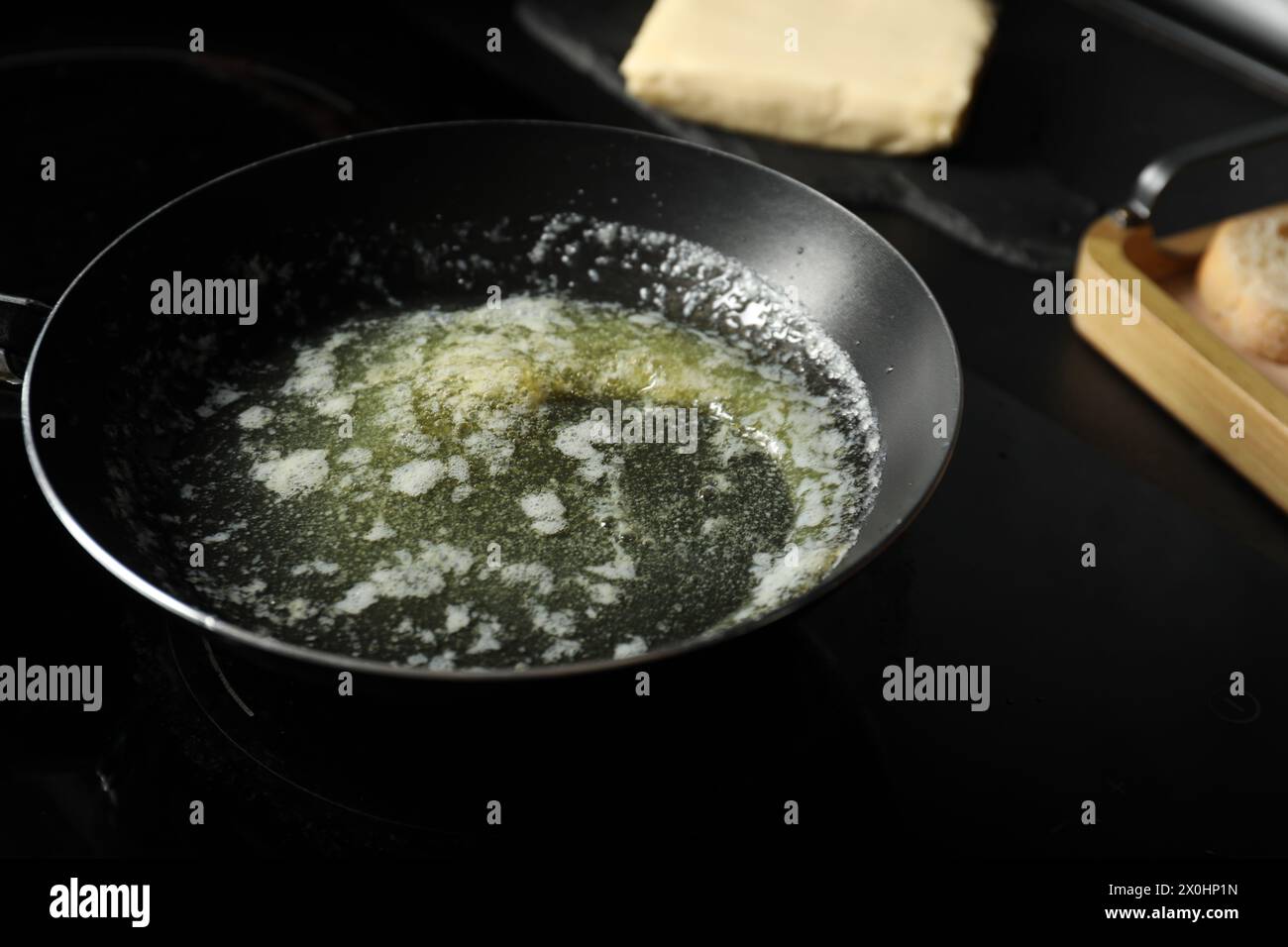 Melting butter in frying pan on cooktop Stock Photo - Alamy