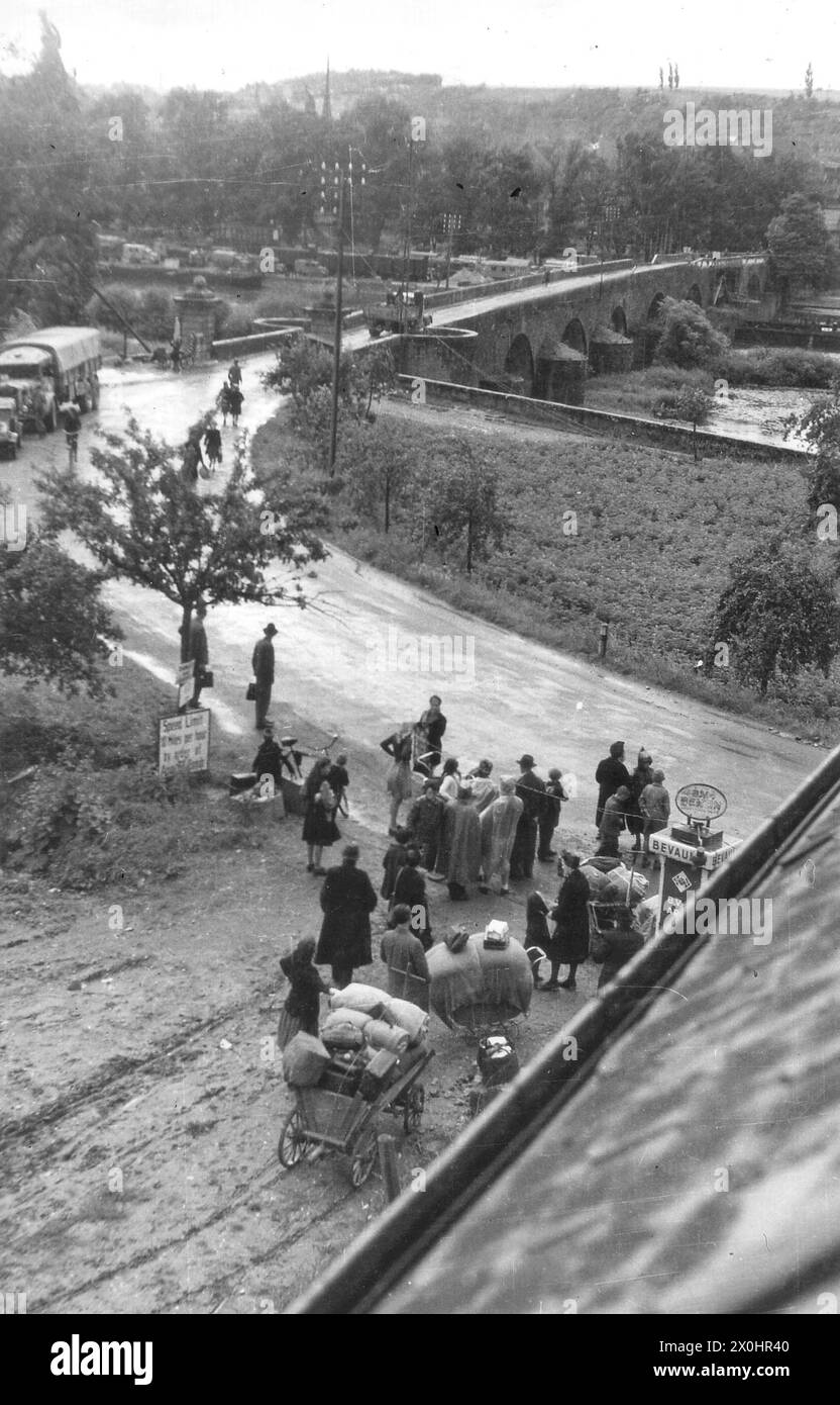 A group of refugees with loaded carts at an Aral petrol station in ...