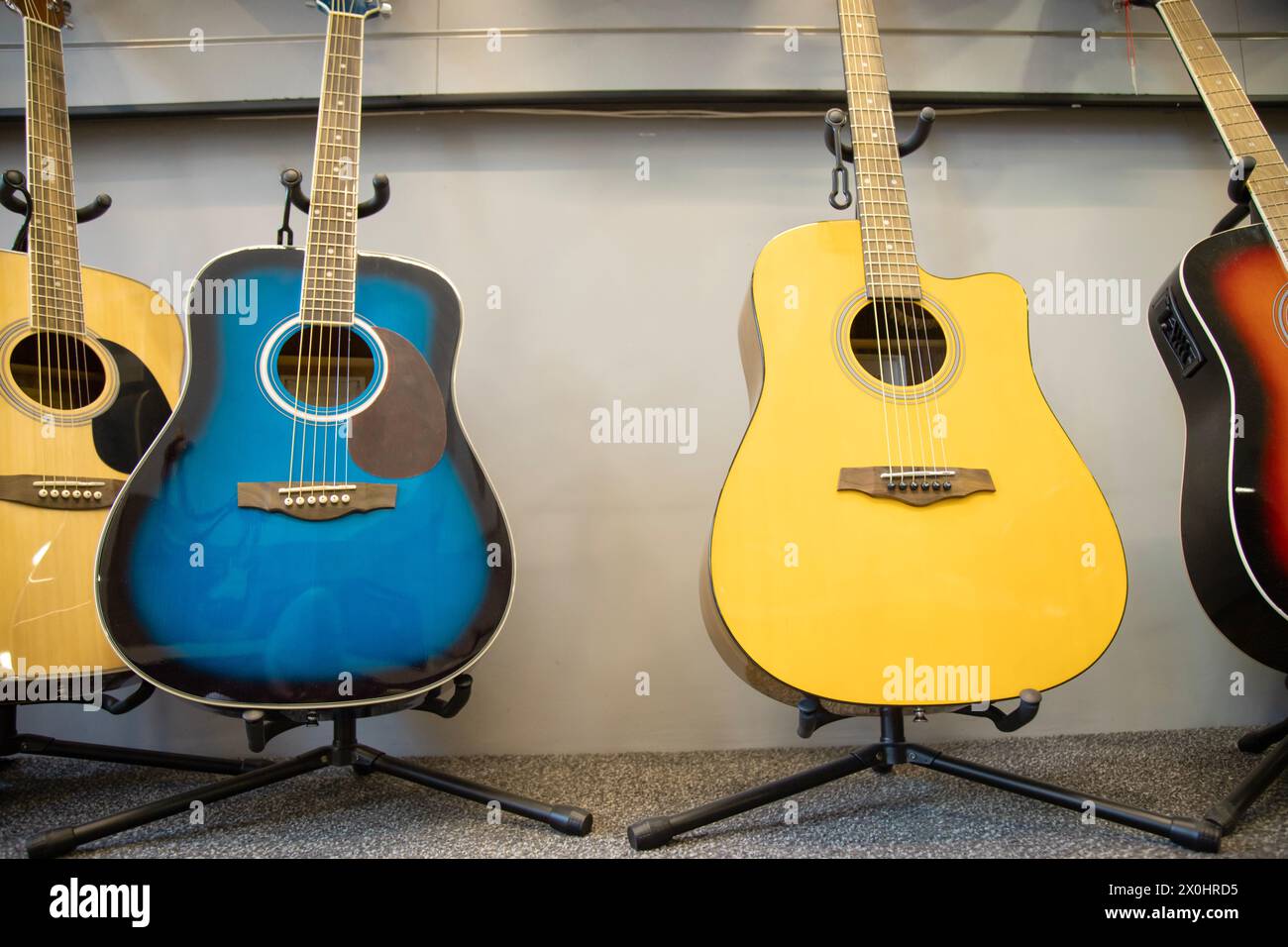 Blue and an yellow guitars at music store Stock Photo - Alamy