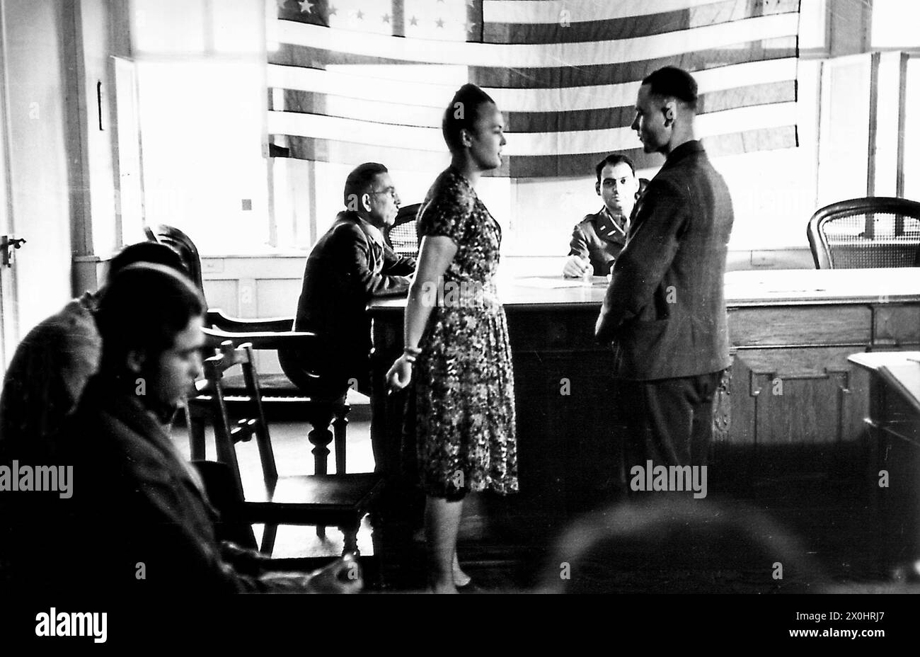 A young German woman in dress is sworn in by the US Lieutenant Feld in ...