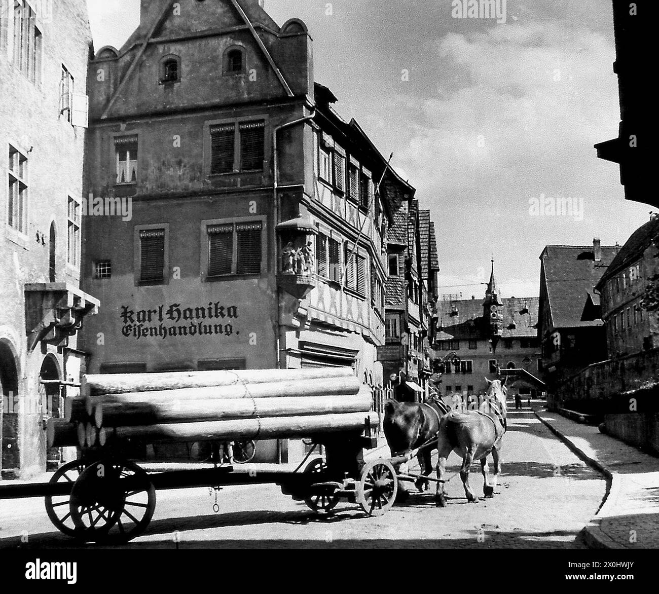 A horse-drawn carriage with tree trunks in the main street of ...
