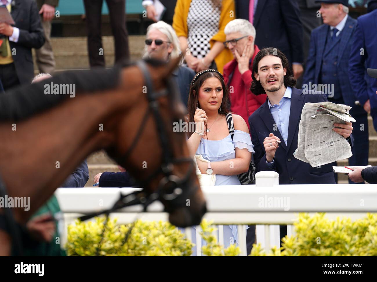 Racegoers outside the parade ring check the form ahead of the William ...