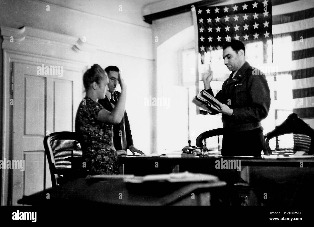 A young German woman in dress is sworn in by the US Lieutenant Feld in ...
