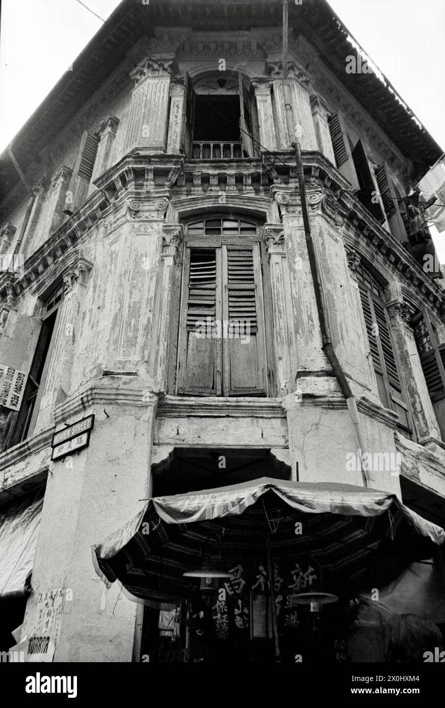 View of a dilapidated corner house in Singapore. In the lower part of ...