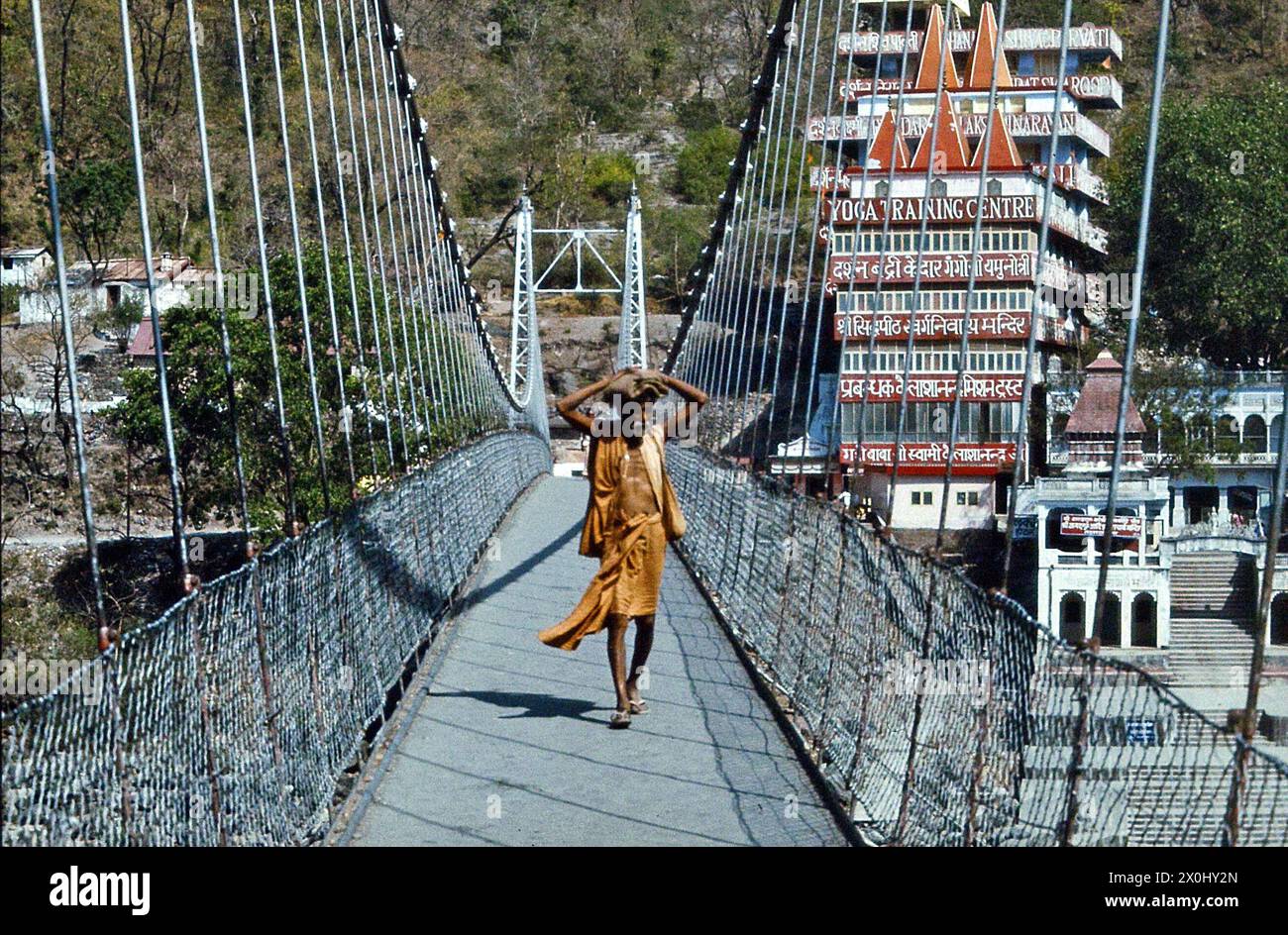 "An old man, a Sadu walks across a suspension bridge in Rishikesh. He ...