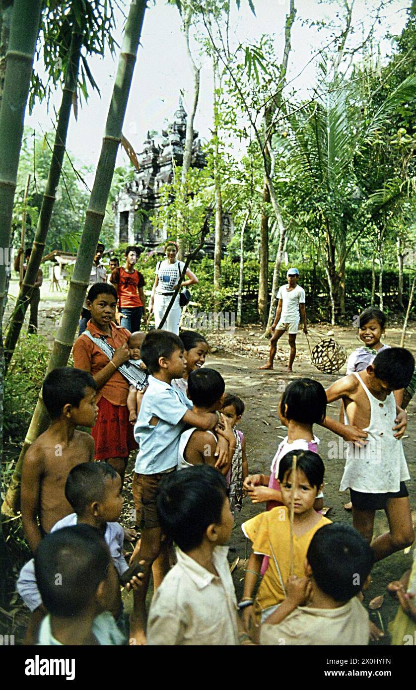 A group of children and young people in a village with the Buddhist ...