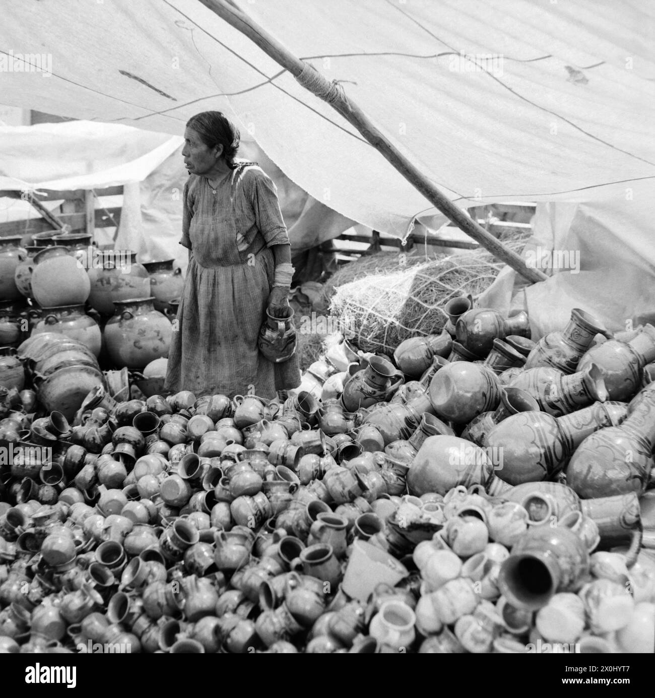 A trader has spread out her goods under a tarpaulin at the market in ...