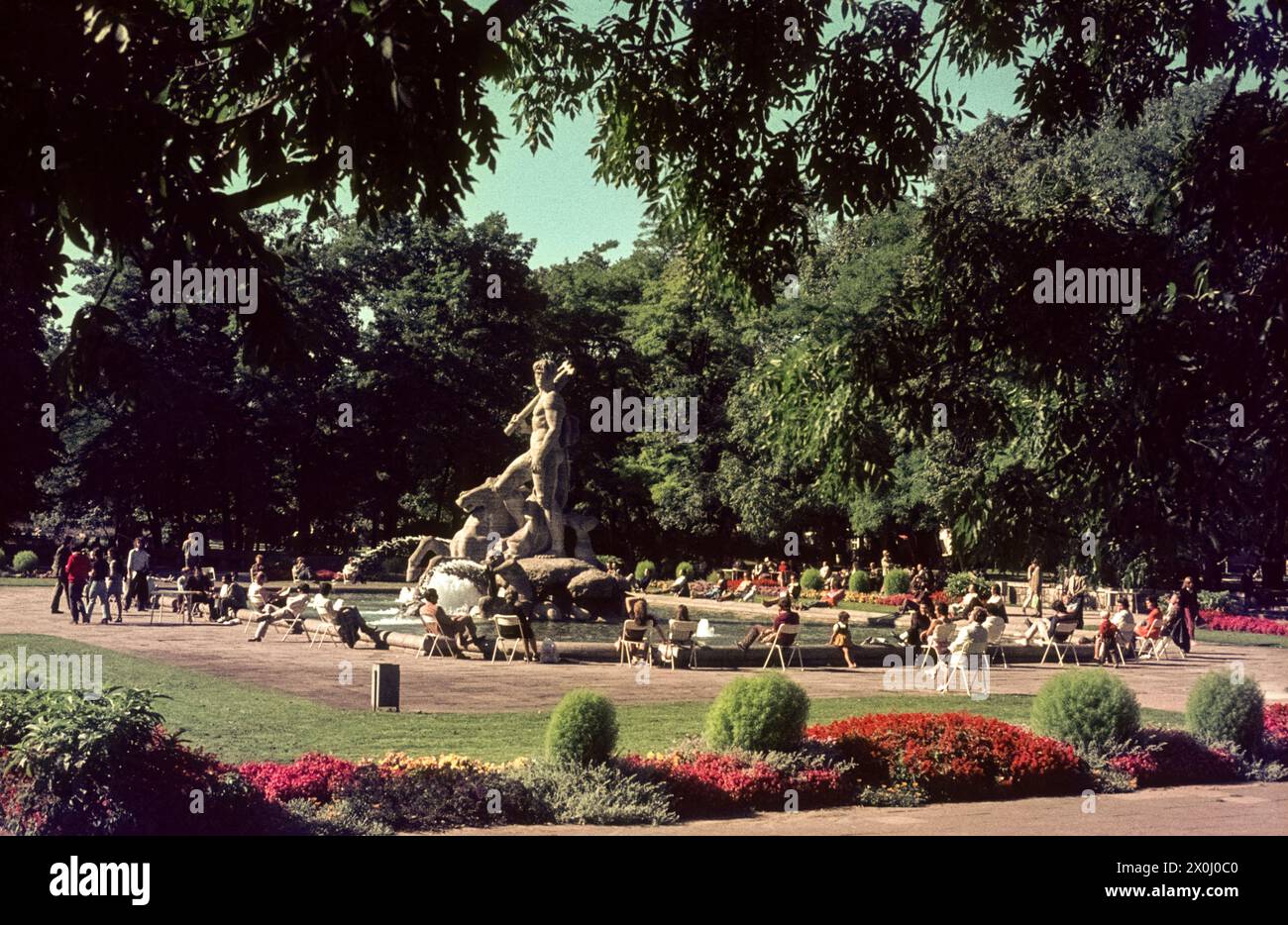 Passers-by enjoy the fall sun at the Neptune Fountain in the Old ...