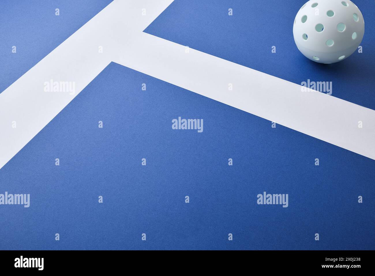 Background with white pickleball ball on a blue playing surface with ...