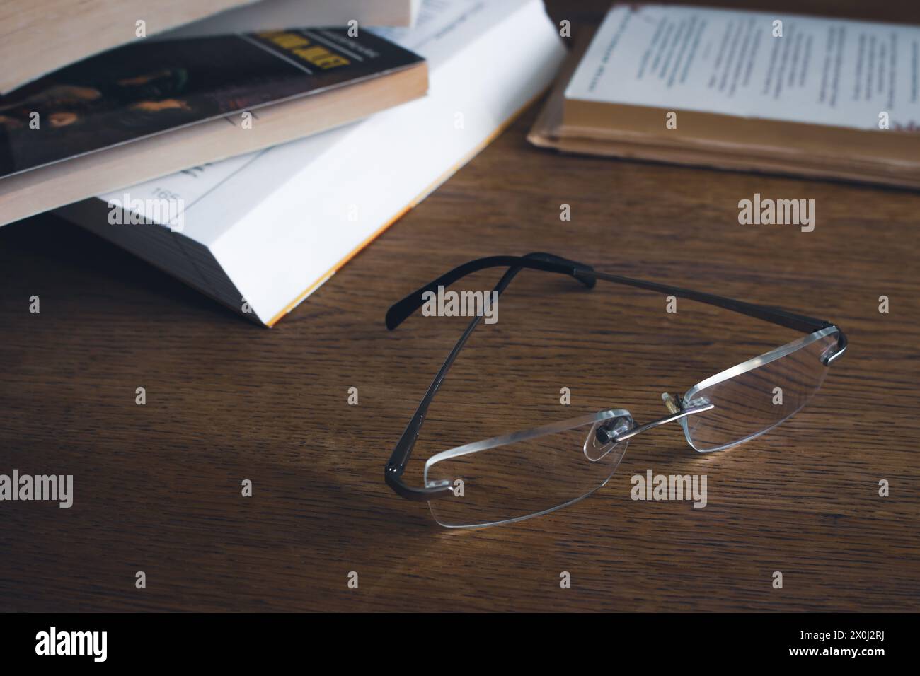 Classic glasses and pile of books on the table. Literature concept ...