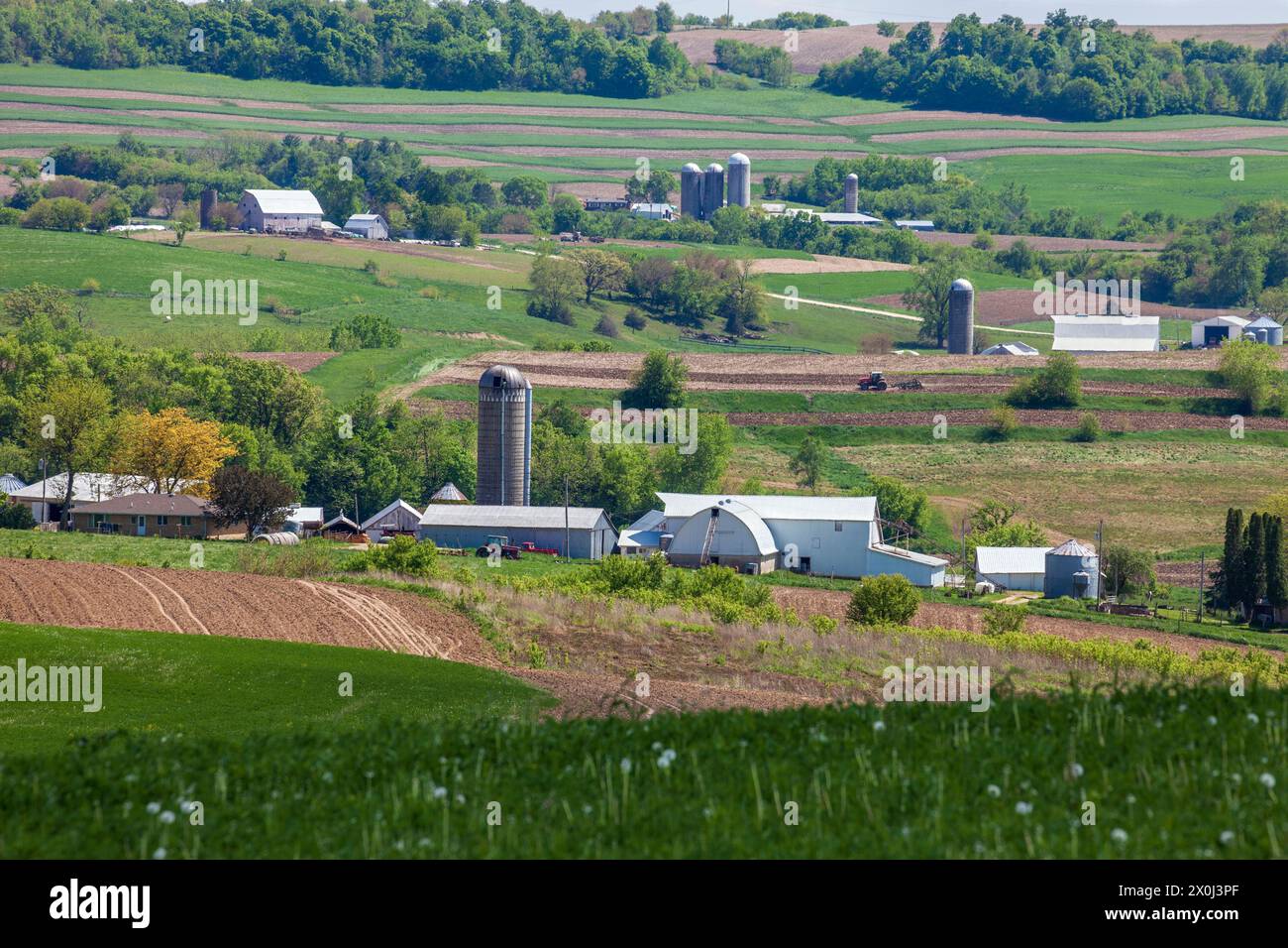 Farms and felds on rolling hills in the Iowa countryside during spring ...