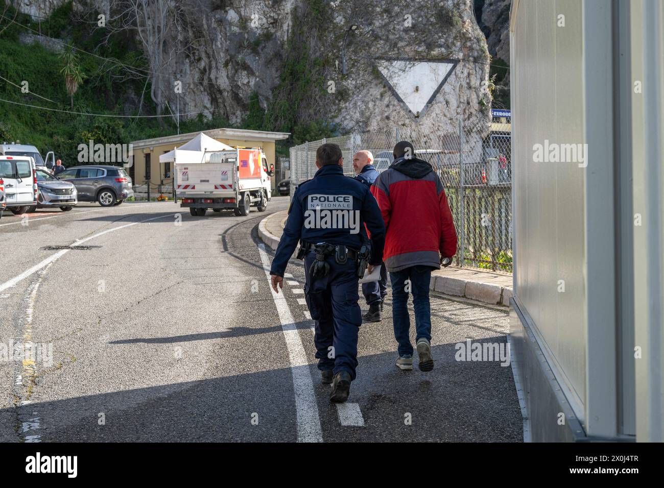 A police officer escorts a migrant back to Italy at the Saint-Louis ...