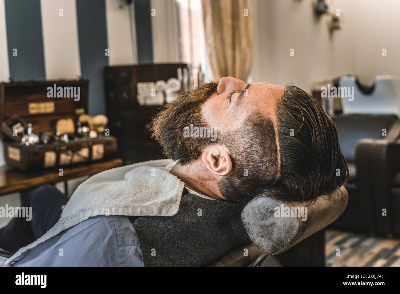 Leisurely moment at upscale barber shop. A client enjoys the serene ...