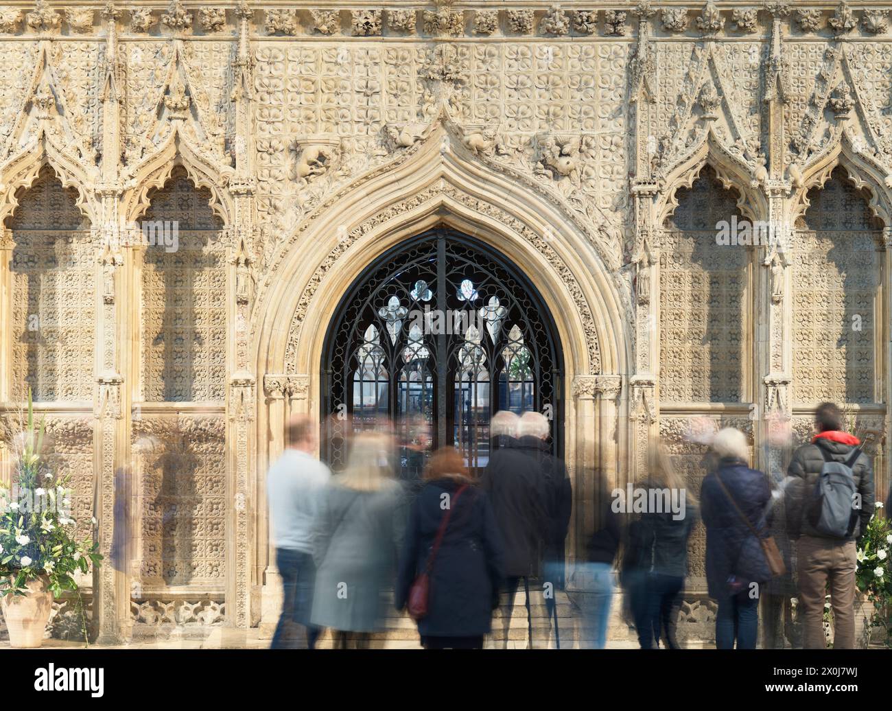 Tourists in front of the gateway through the decorated stone rood ...