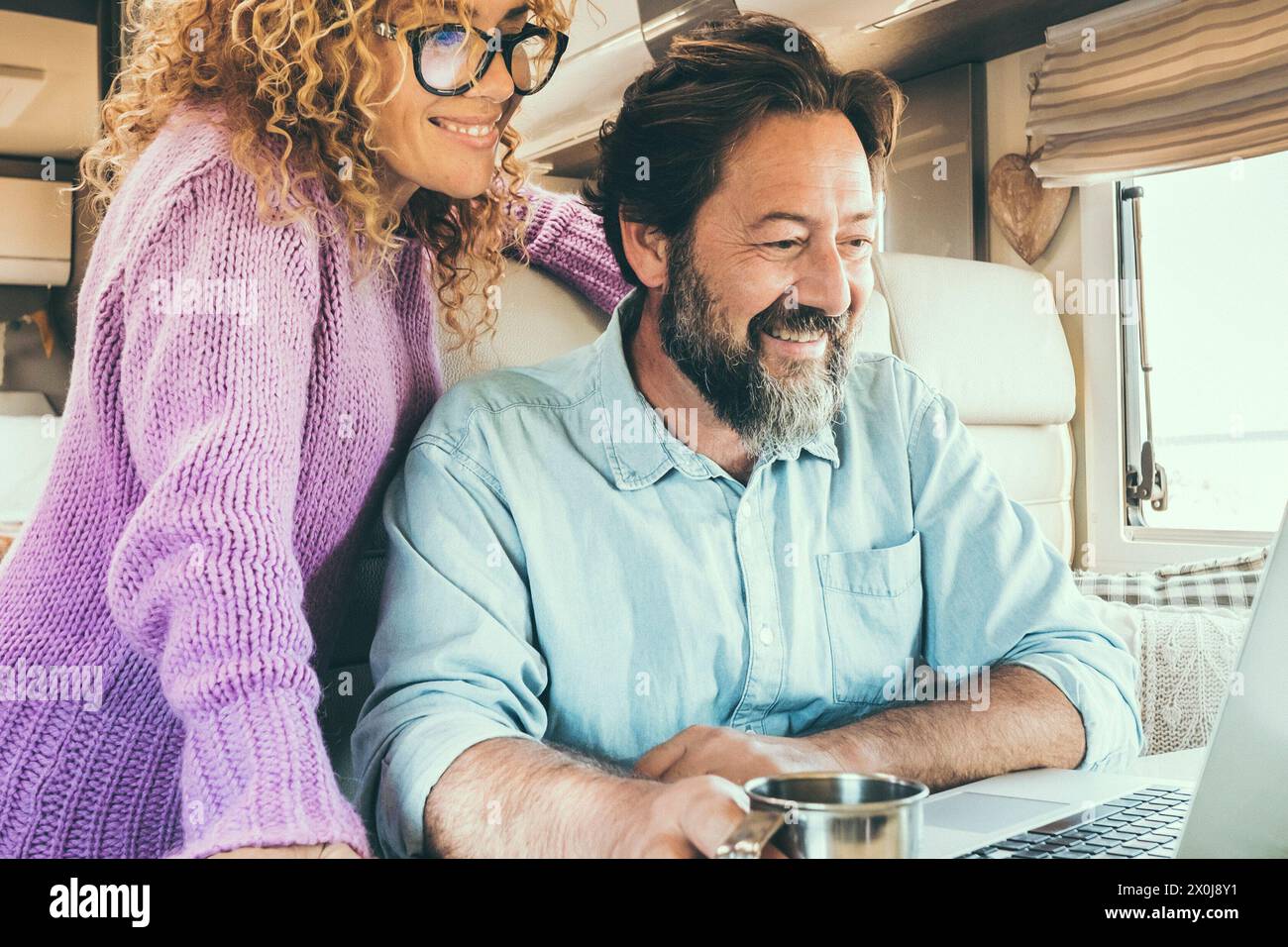 Modern travel couple enjoy connection technology using laptop inside a ...