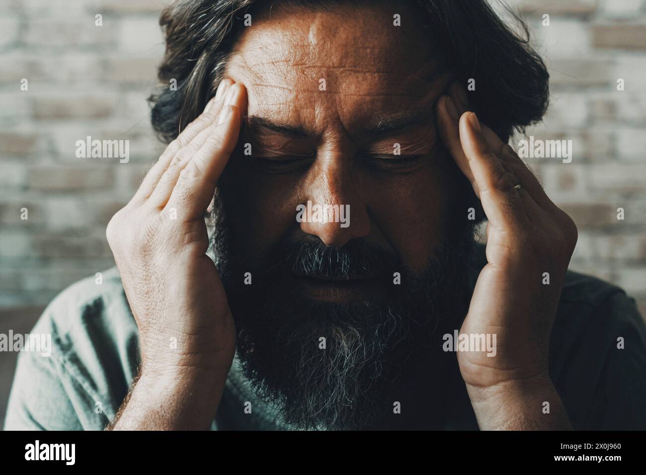 Close up portrait of man touching his head and temples for headache or ...